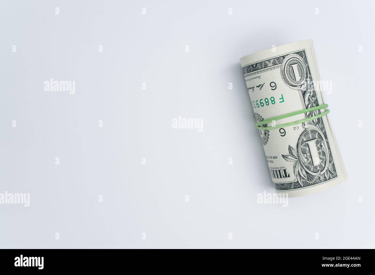 Closeup of a roll of money on light gray background Stock Photo - Alamy
