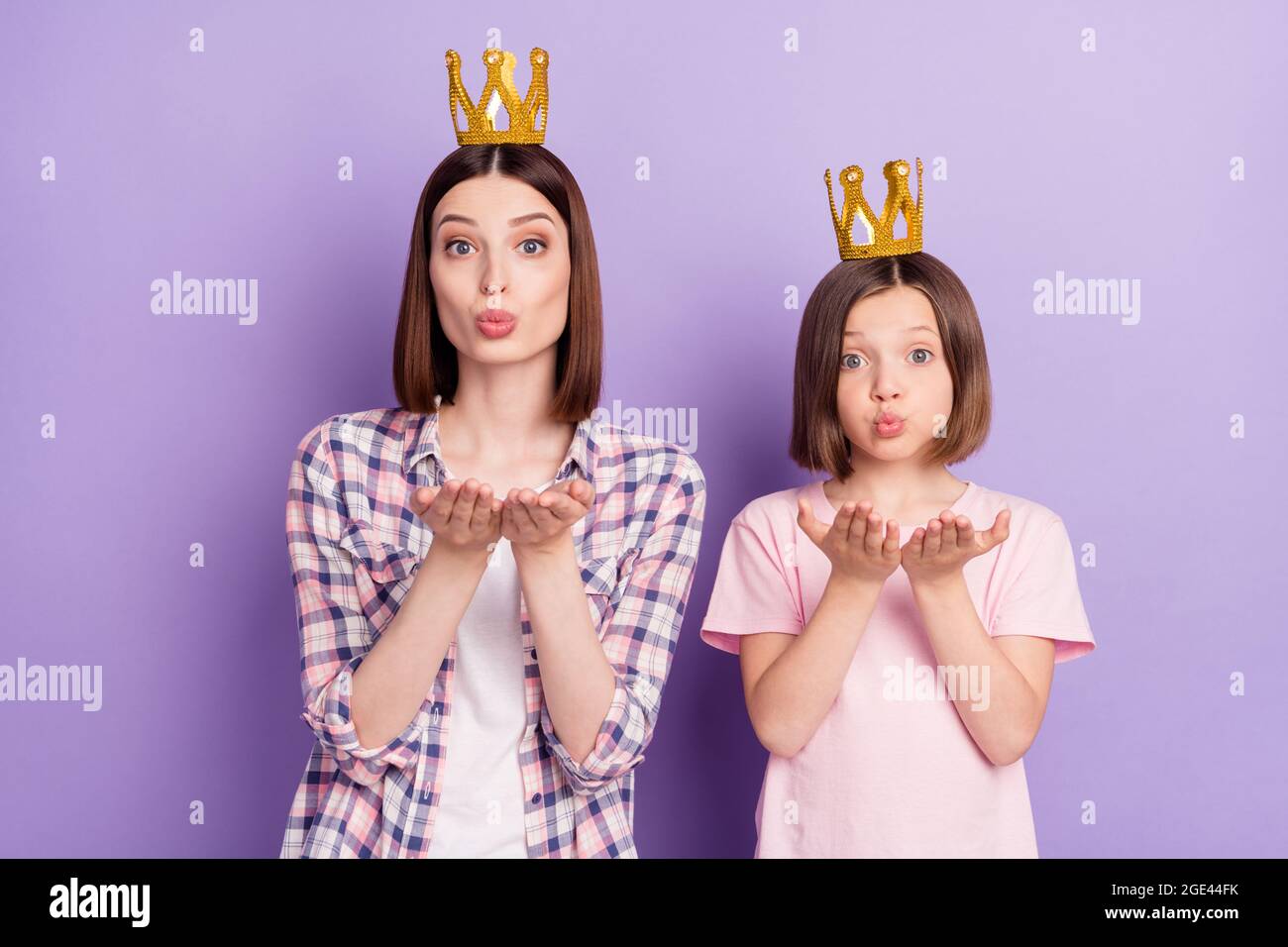 Portrait of two lovely trendy affectionate girls wearing crown sending ...