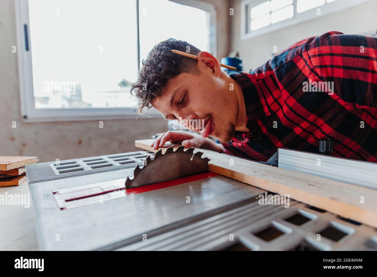 Caucasian male carpenter carefully cutting wood Stock Photo - Alamy