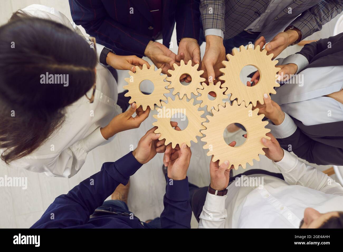 Business team people hands holding gear wheels shot with view from ...