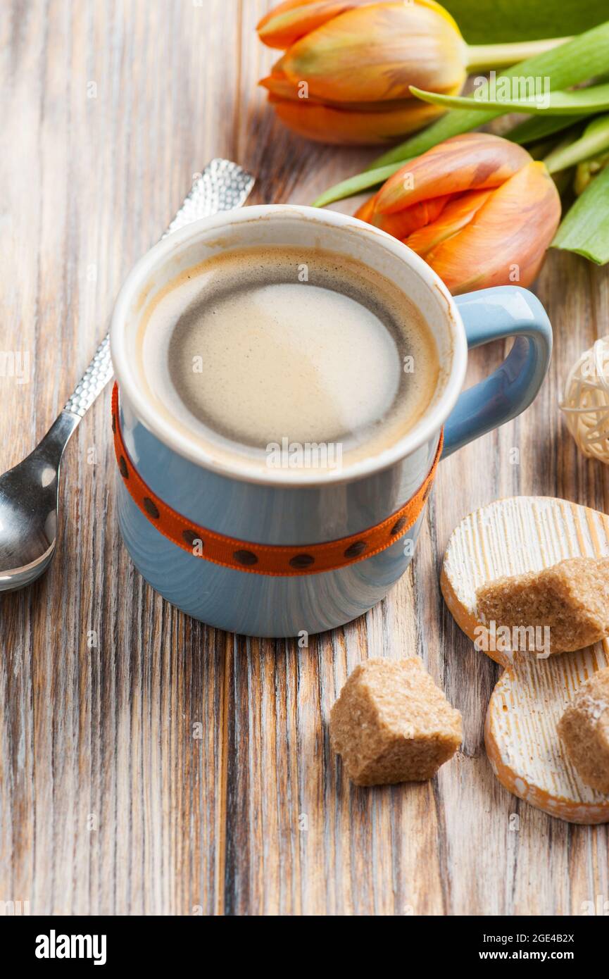 Blue ceramic cup of black hot coffee with brown sugar cubes and spoon ...