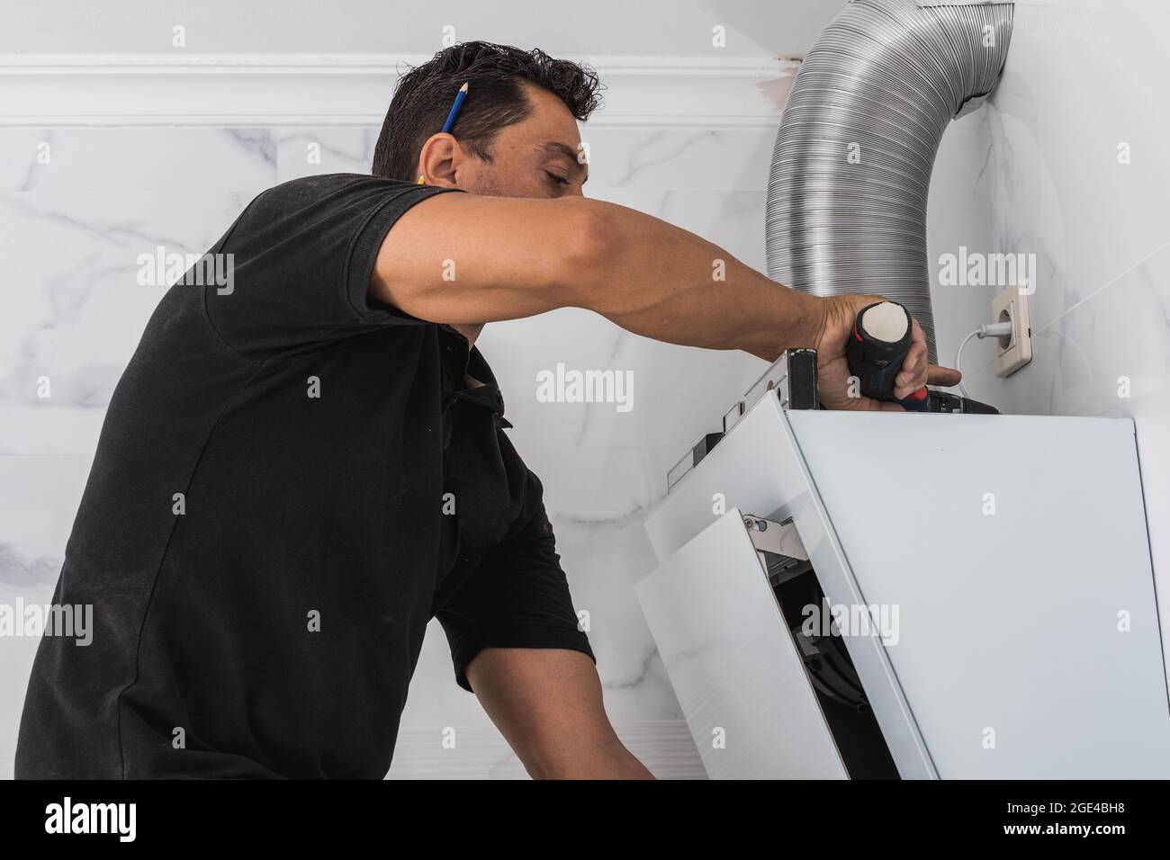 Man putting up a new kitchen cabinet Stock Photo - Alamy