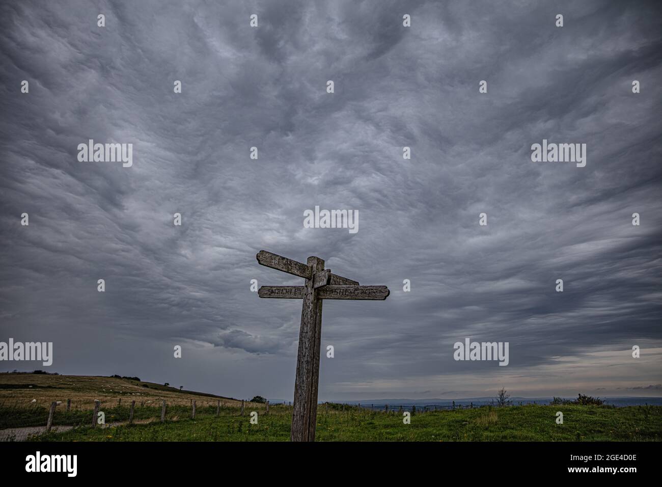 Gloomy autumn day with gray clouds hovering over a green field with a ...