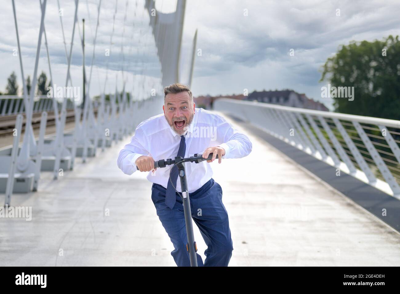 Businessman screaming in panic as he speeds along on a scooter at an ...