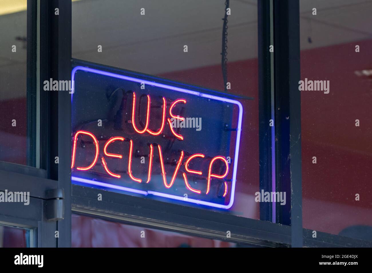 red blue neon sign says we deliver Stock Photo - Alamy