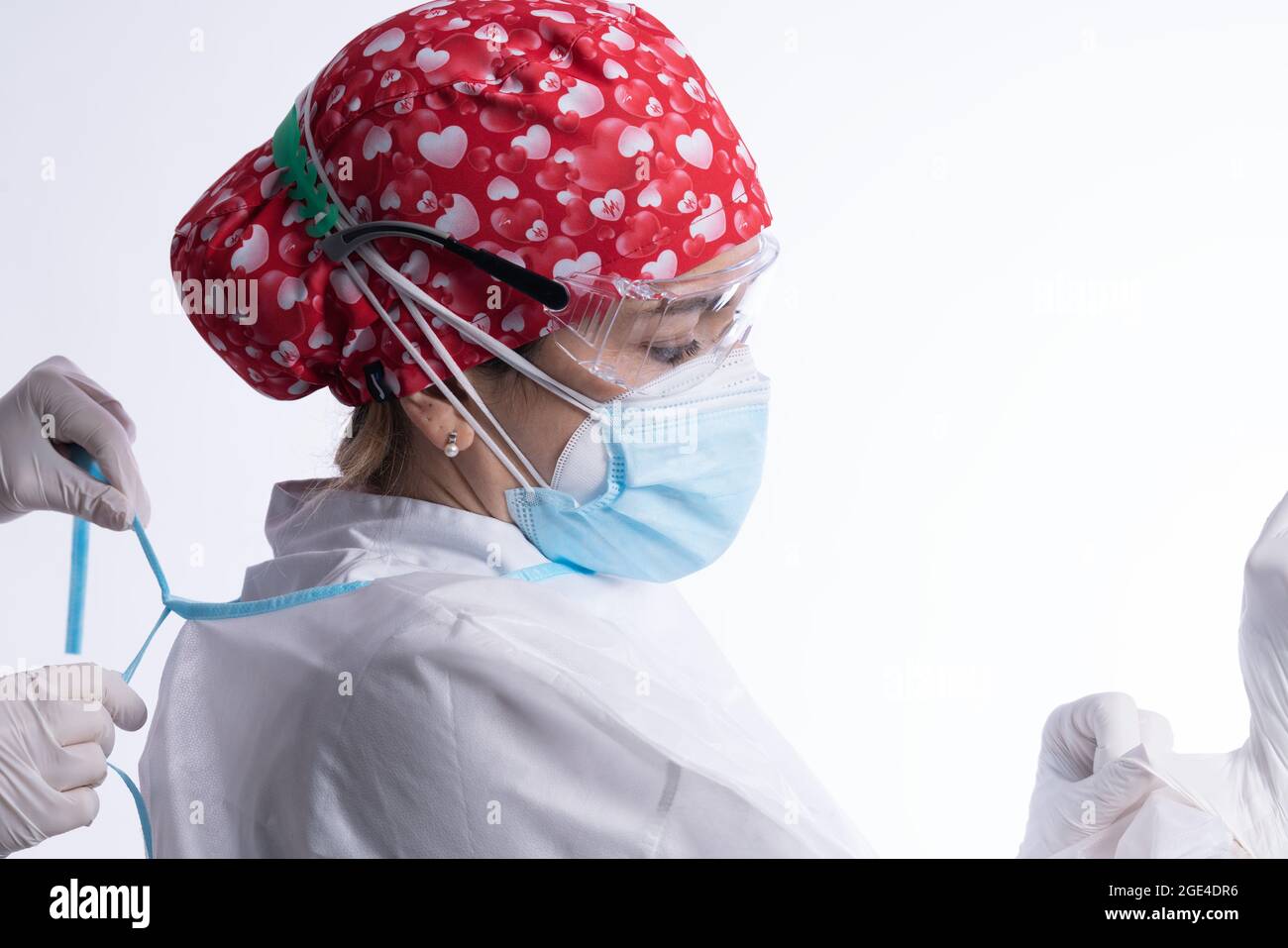 Closeup of a female nurse getting her medical apron tied while wearing ...