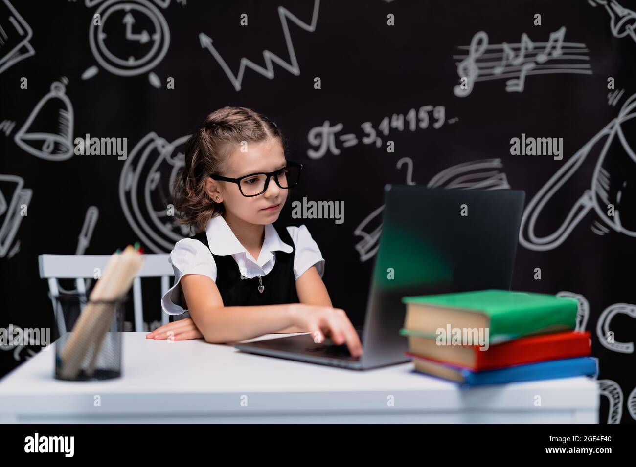 little schoolgirl with glasses looking to the computer, on school ...