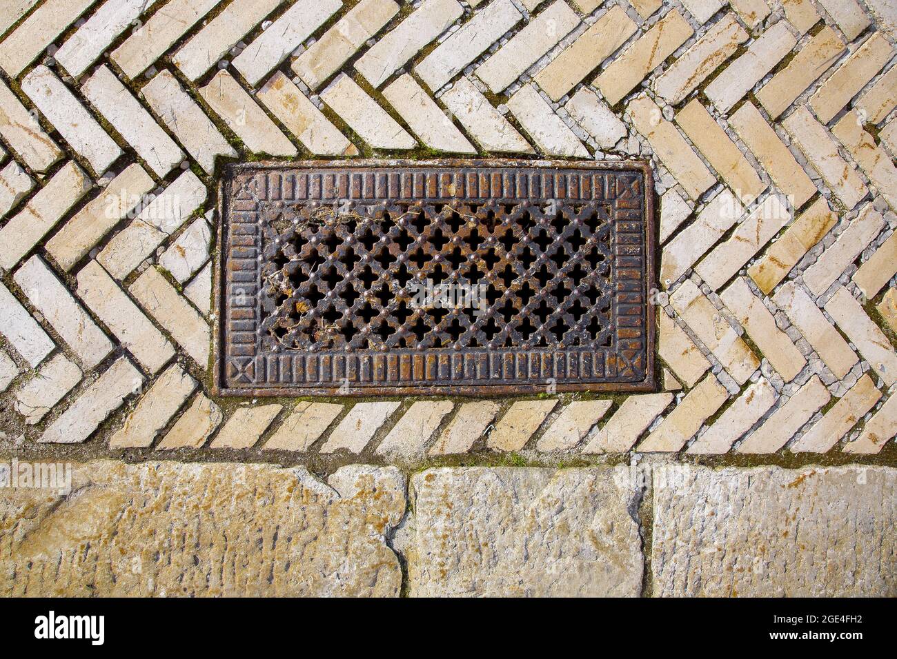 iron rusty rectangular manhole with shaped holes in the lid on the ...