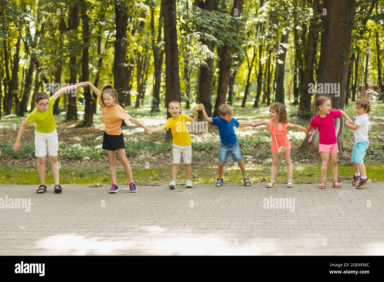 Summer camp kids making wave, holding hands together Stock Photo - Alamy
