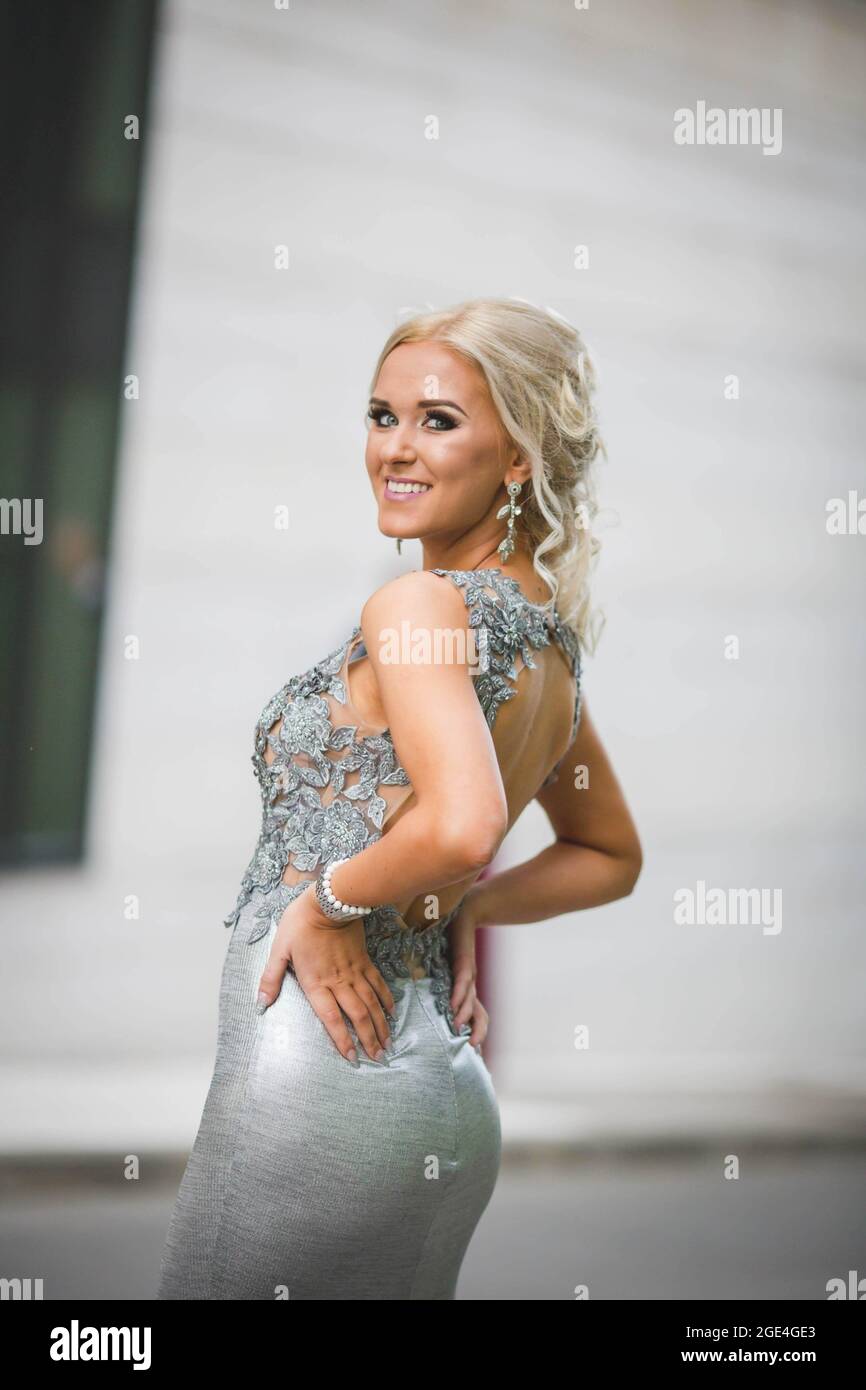 Closeup shot of a young woman posing in a silver dress with an open ...
