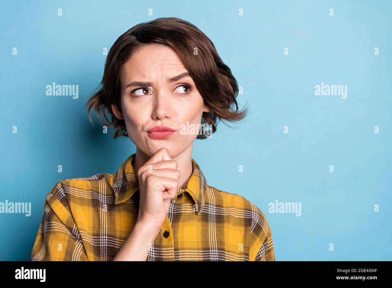 Photo of minded creative doubtful girl finger chin look empty space ...