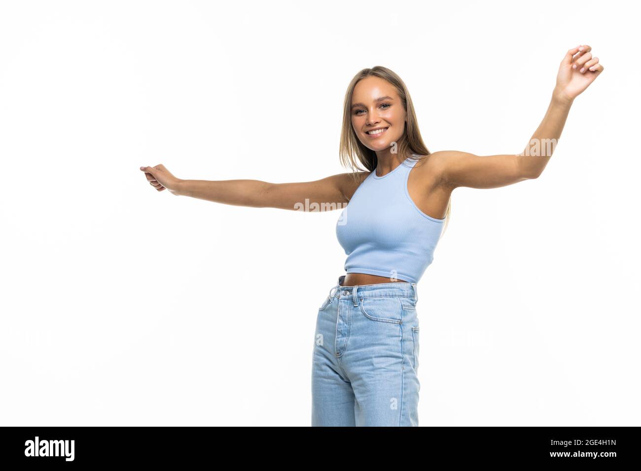 Young happy woman dancing against white background Stock Photo - Alamy