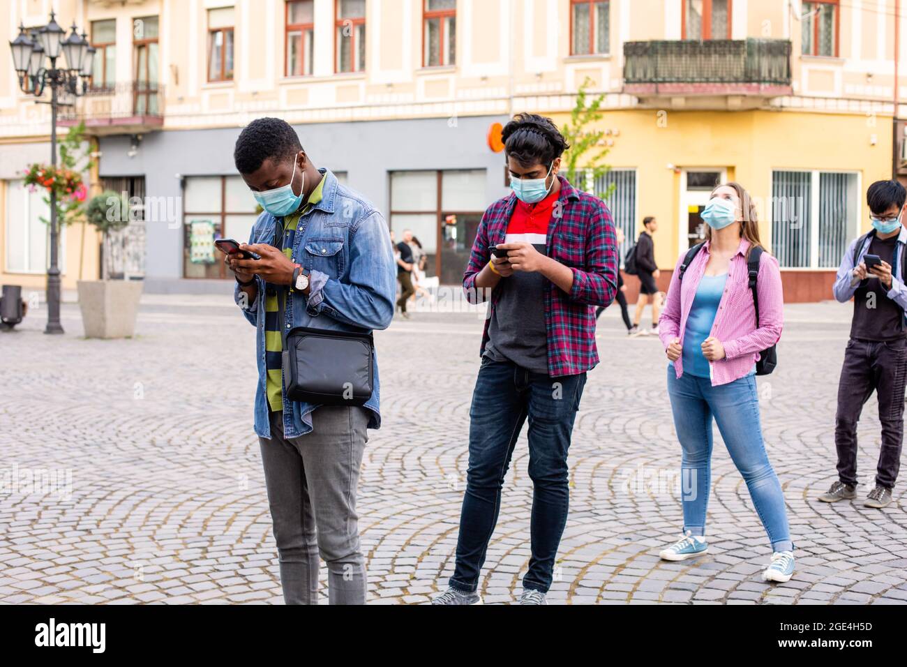 People in masks stand queue keeping social distance Stock Photo - Alamy