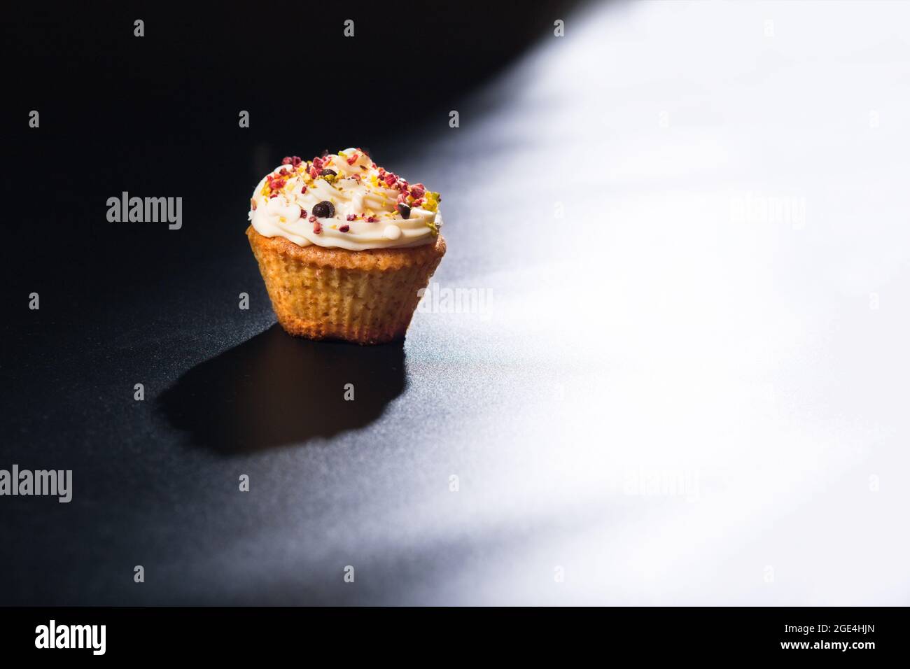 One cup cake close up on black background with copy space. Muffin with ...