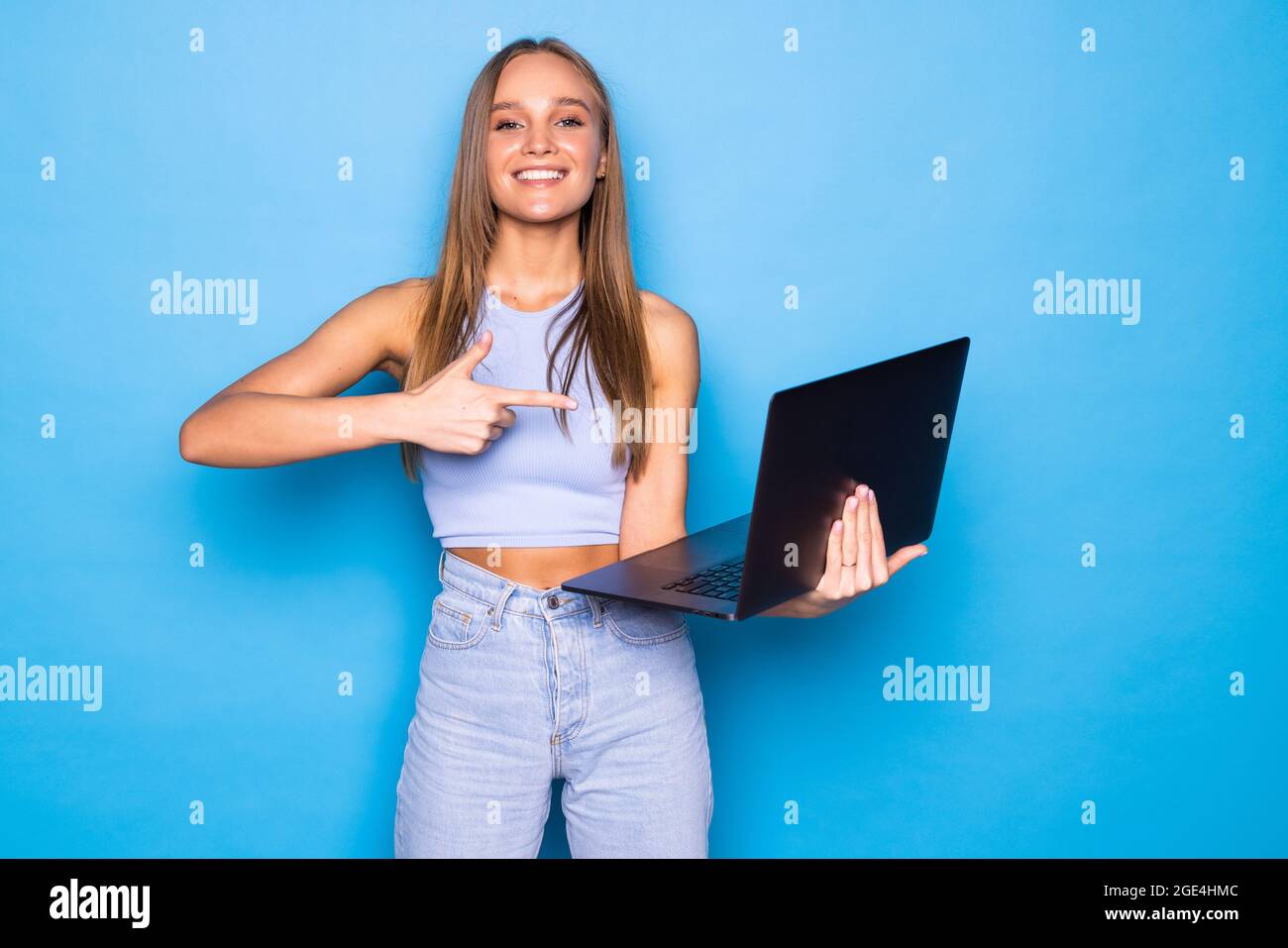 Portrait of a happy beautiful woman pointing finger at blank screen ...