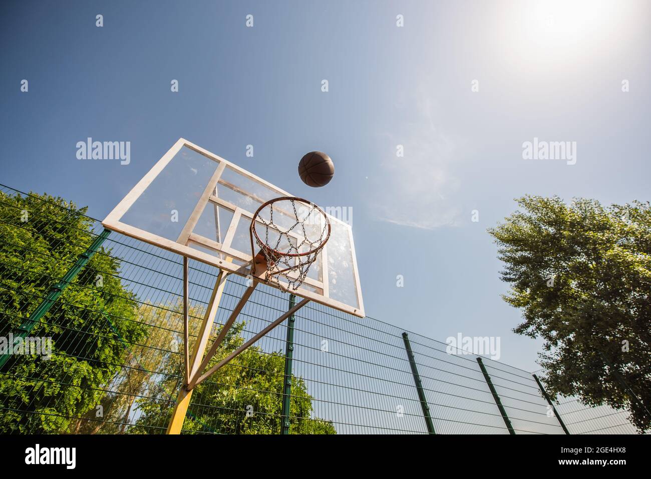 Low angle view of basketball ball near hoop on playground outdoors ...