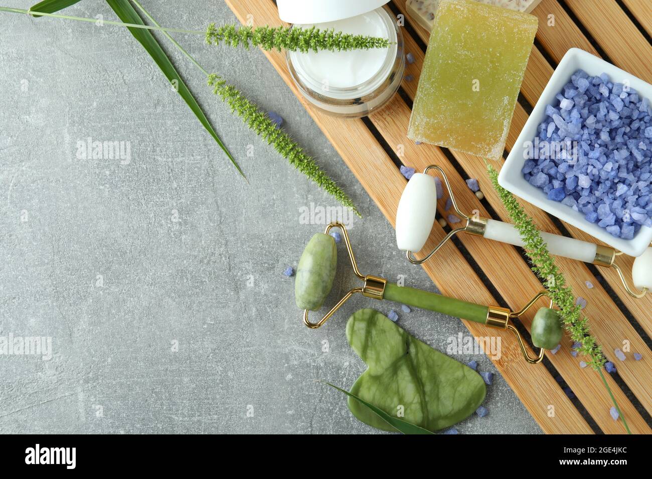 Skin care beauty concept with face rollers on gray textured background ...