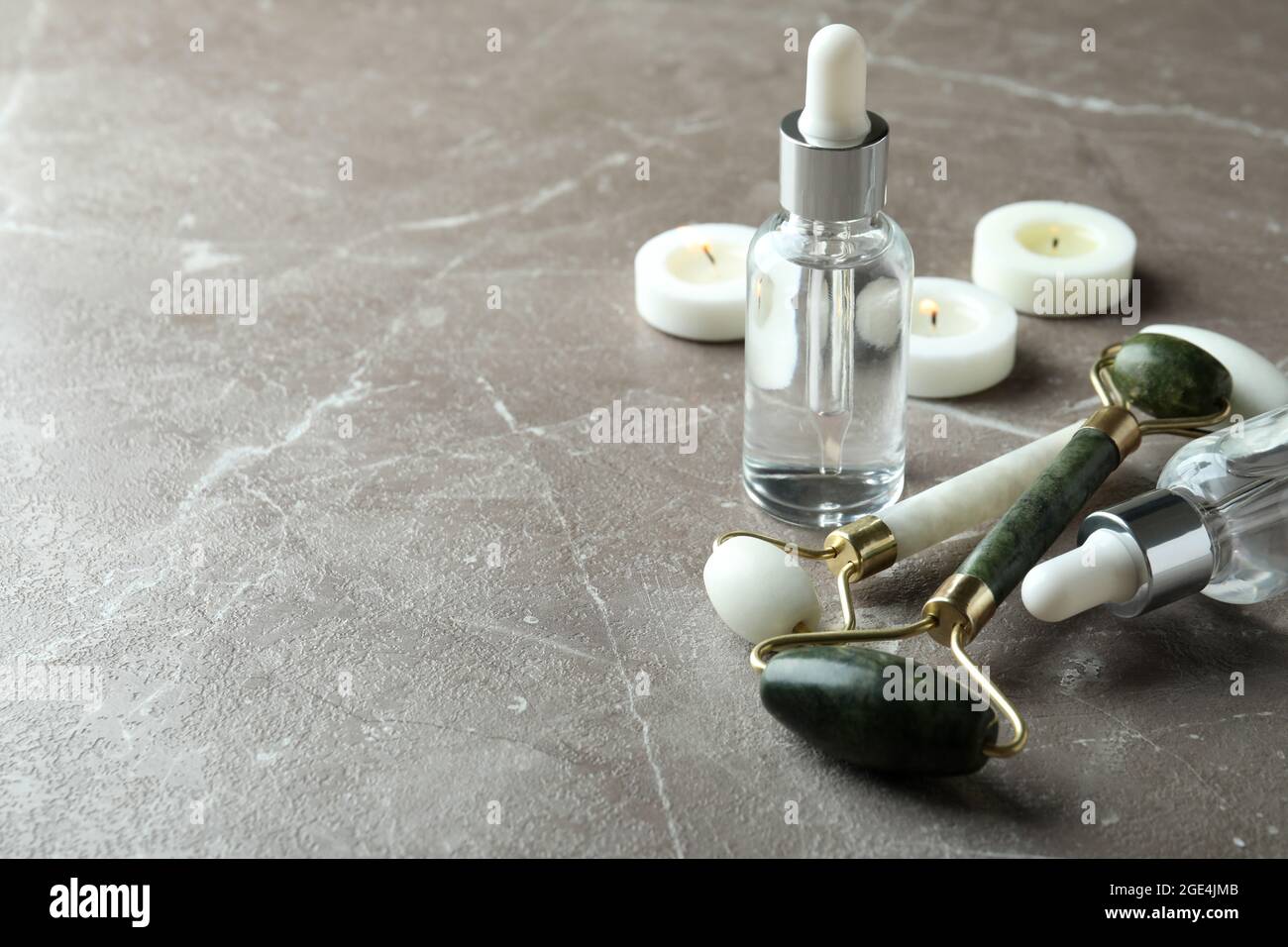 Skin care concept with face rollers on gray textured table Stock Photo ...
