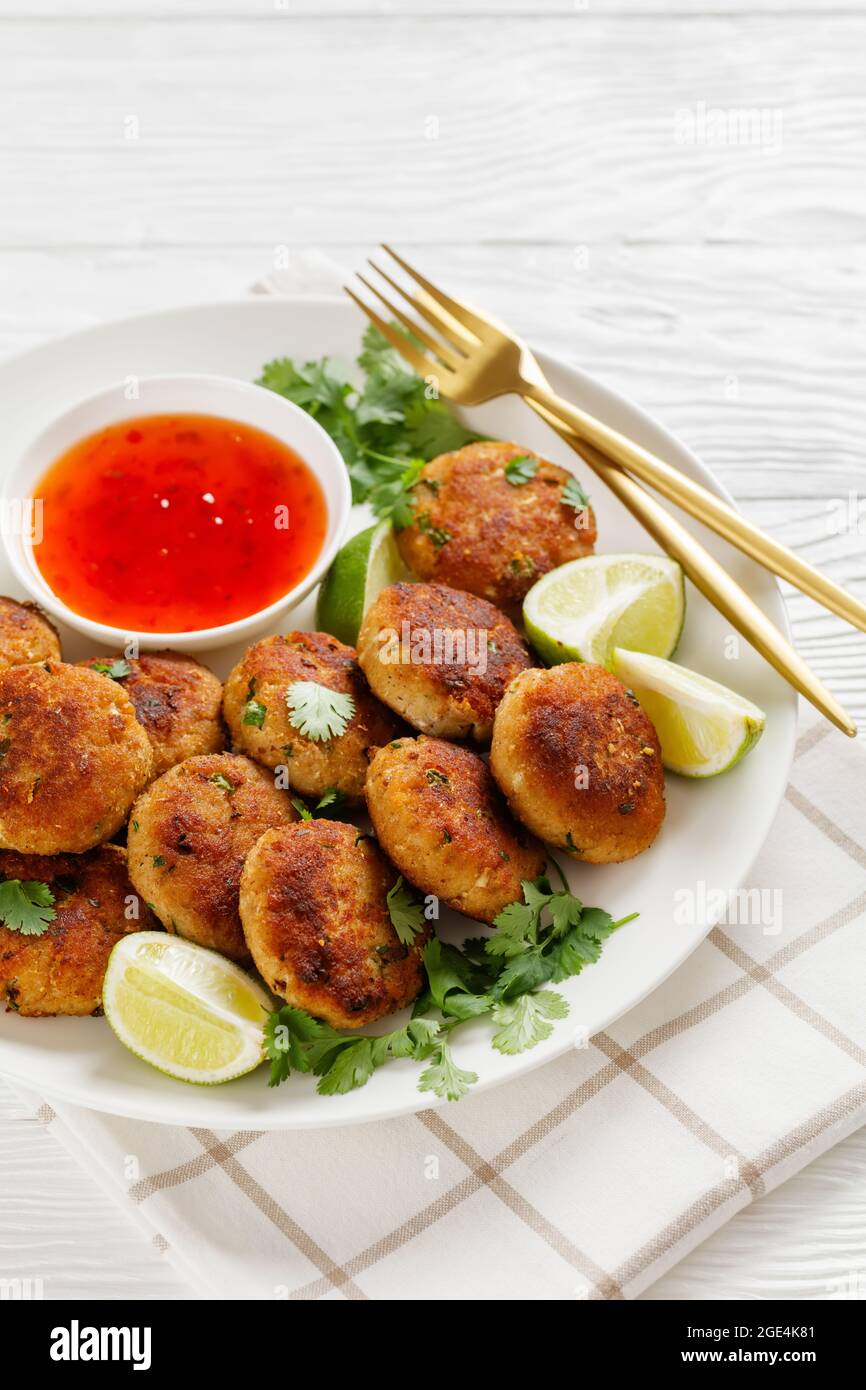 Tod man pla, thai fish cakes with sweet chili sauce on a white plate ...