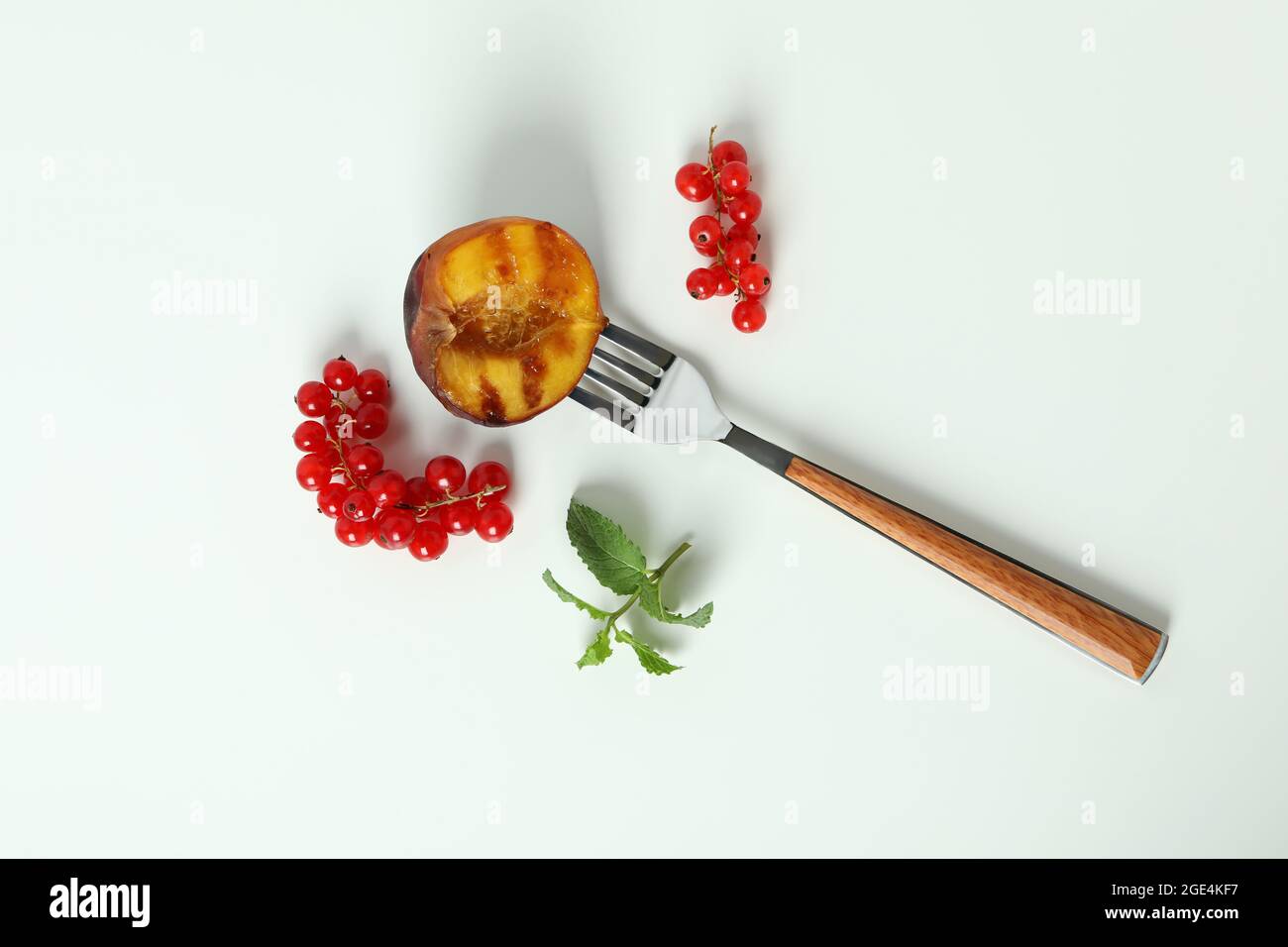 Fork with grilled peach on white background Stock Photo - Alamy