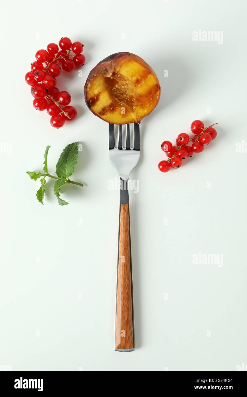 Fork with grilled peach on white background Stock Photo - Alamy