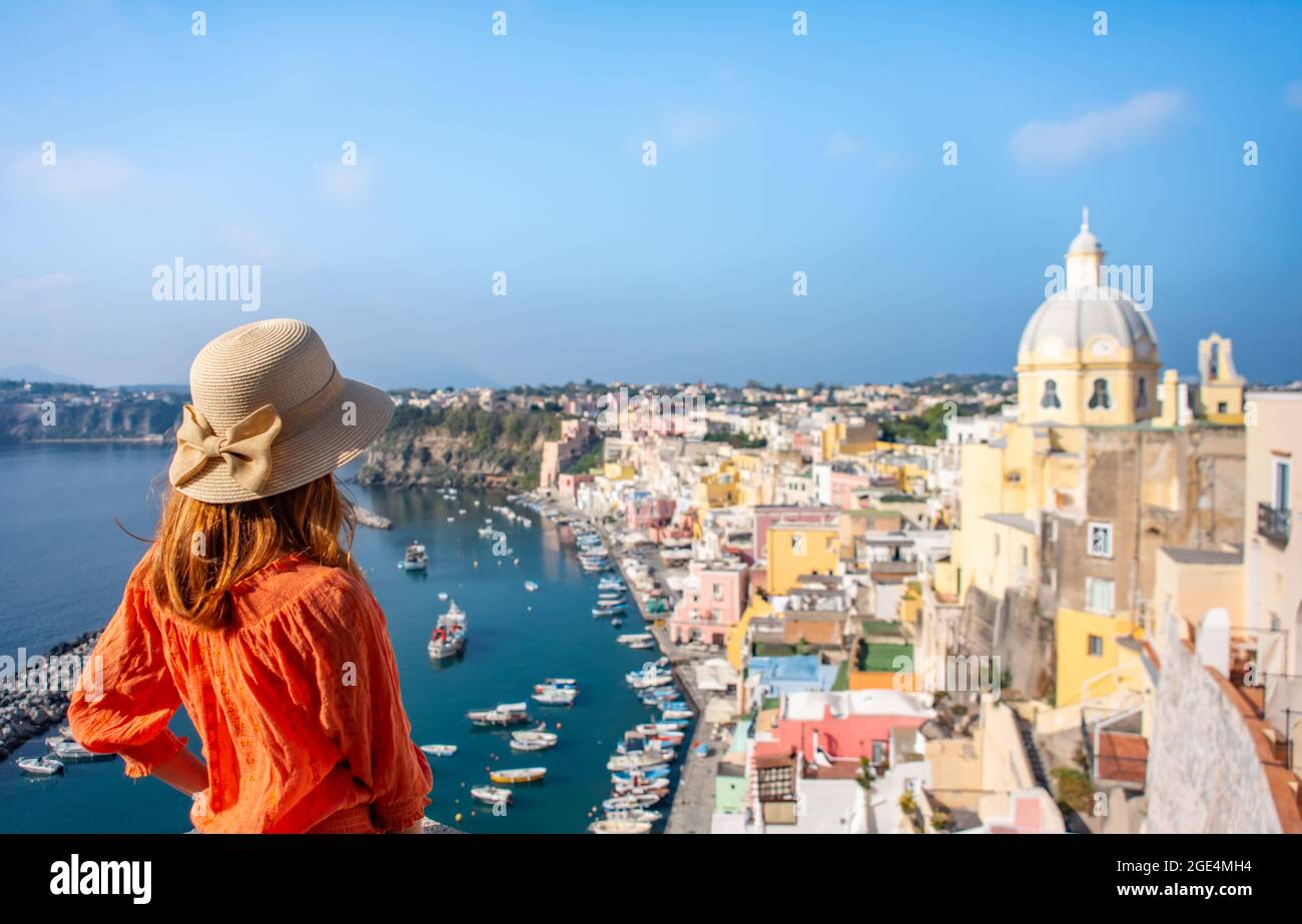 Beautiful young girl over panoramic view of Procida Island, Naples ...