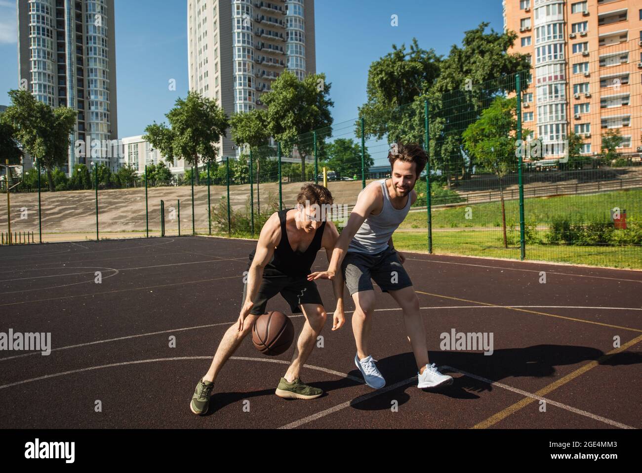 Young men training while playing basketball on playground Stock Photo ...