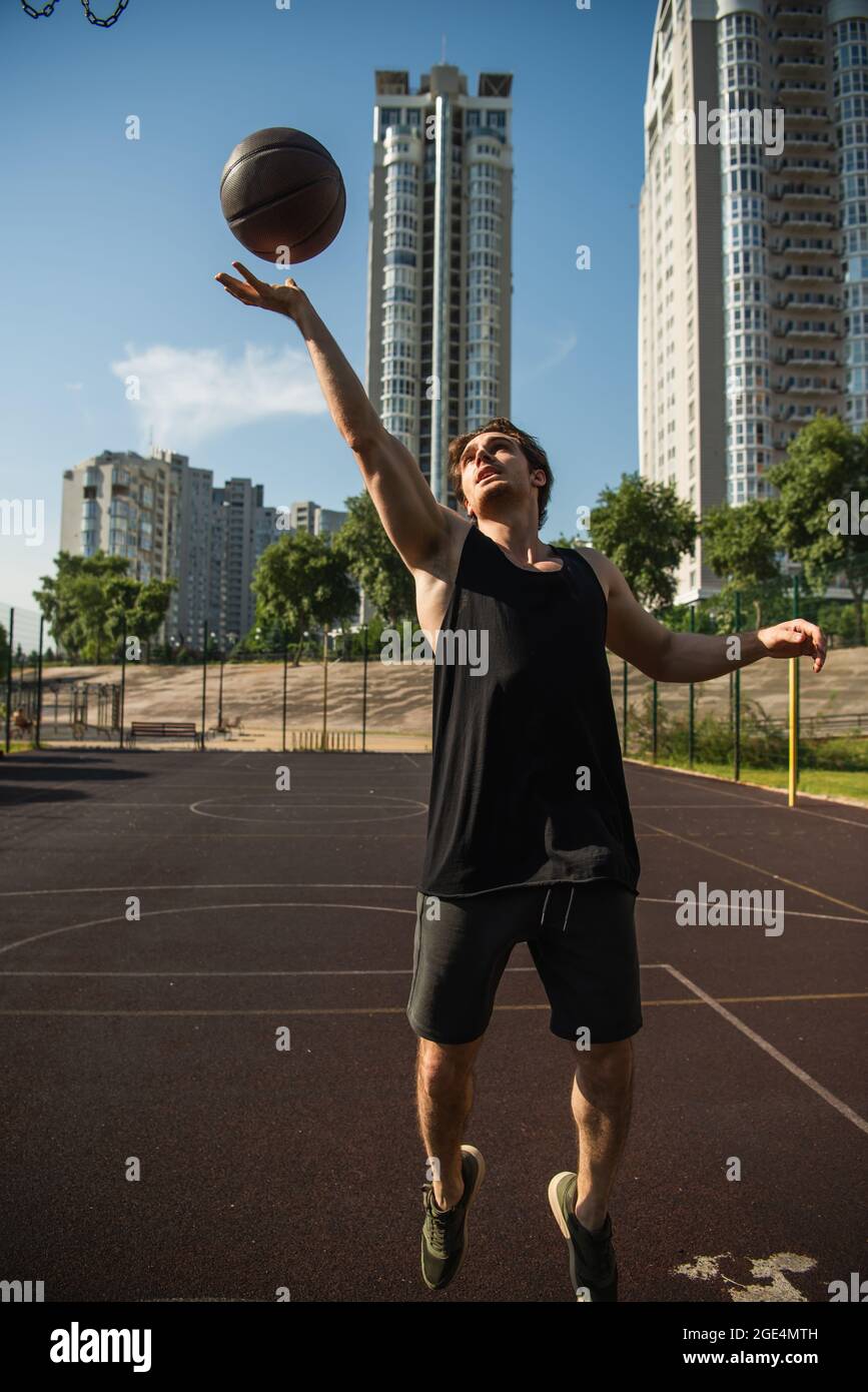 Player jumping and throwing basketball ball on playground Stock Photo ...