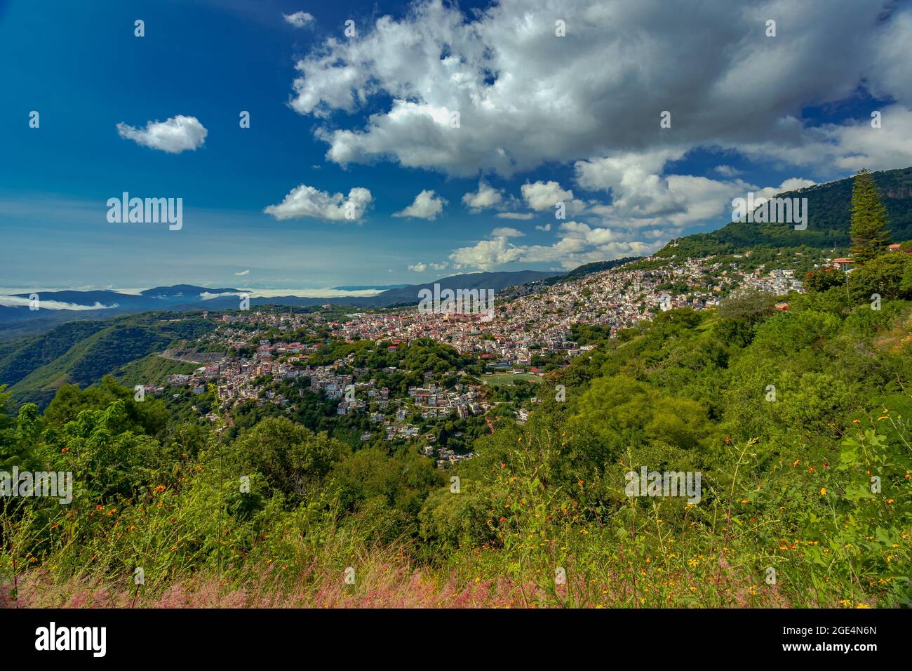 Cloudy sky over the town and hill with greenery Stock Photo - Alamy