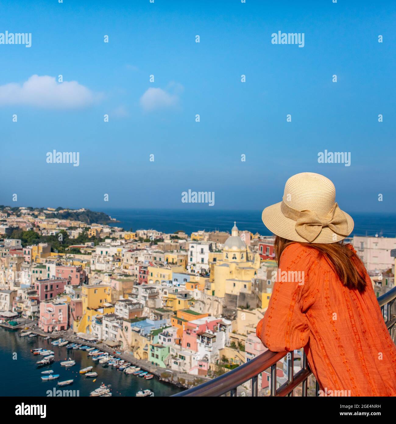 Beautiful young girl over panoramic view of Procida Island, Naples ...