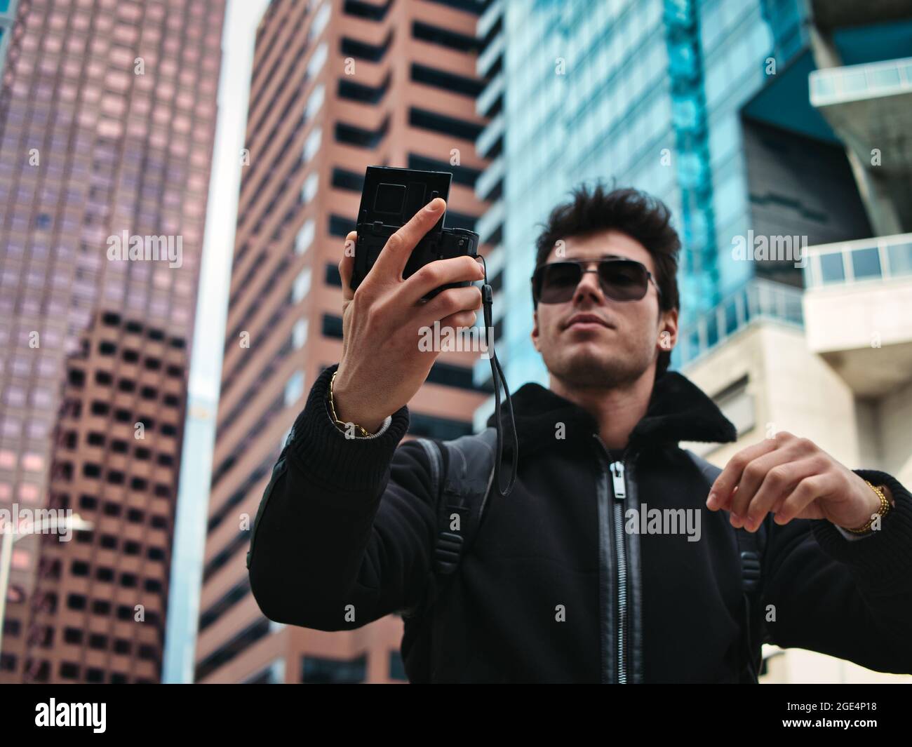 Young man in modern city setting, using smartphone Stock Photo - Alamy
