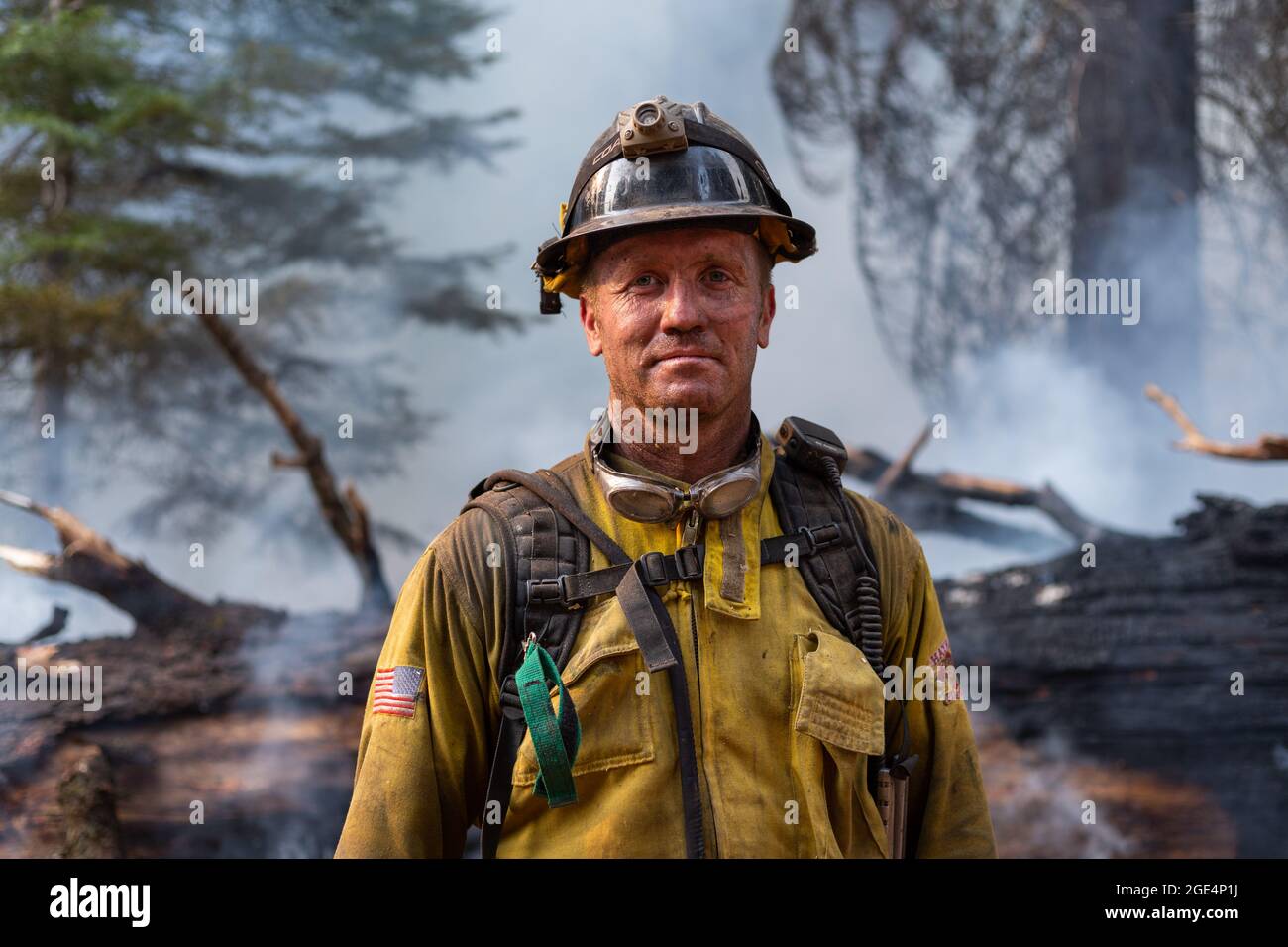 Firefighter Tim Emick, 41, poses in front of a smoking tree while ...