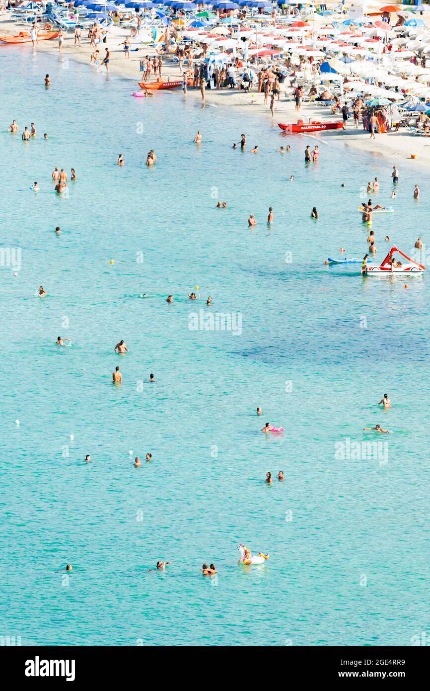 Aerial view of some tourists playing, swimming and sunbathing on a ...
