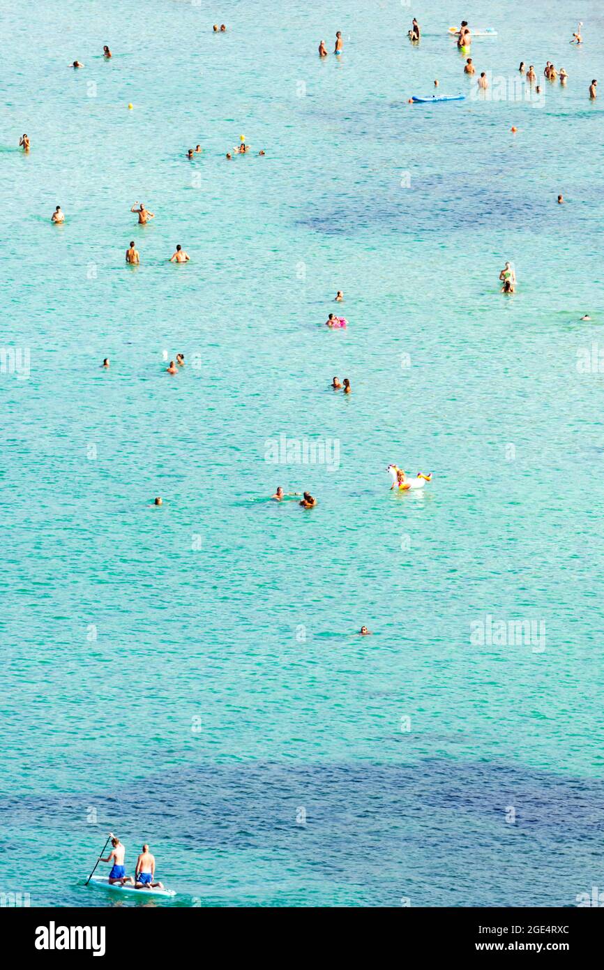 Aerial view of some tourists playing, swimming and sunbathing on a ...