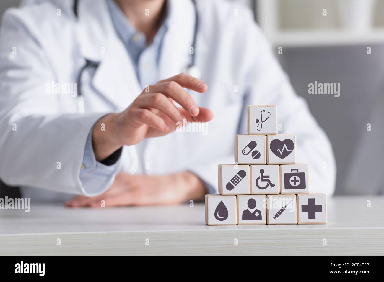 pyramid of cubes with medical signs near blurred physician in white ...