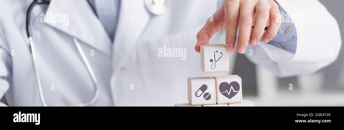 partial view of doctor making pyramid of cubes with medical icons ...