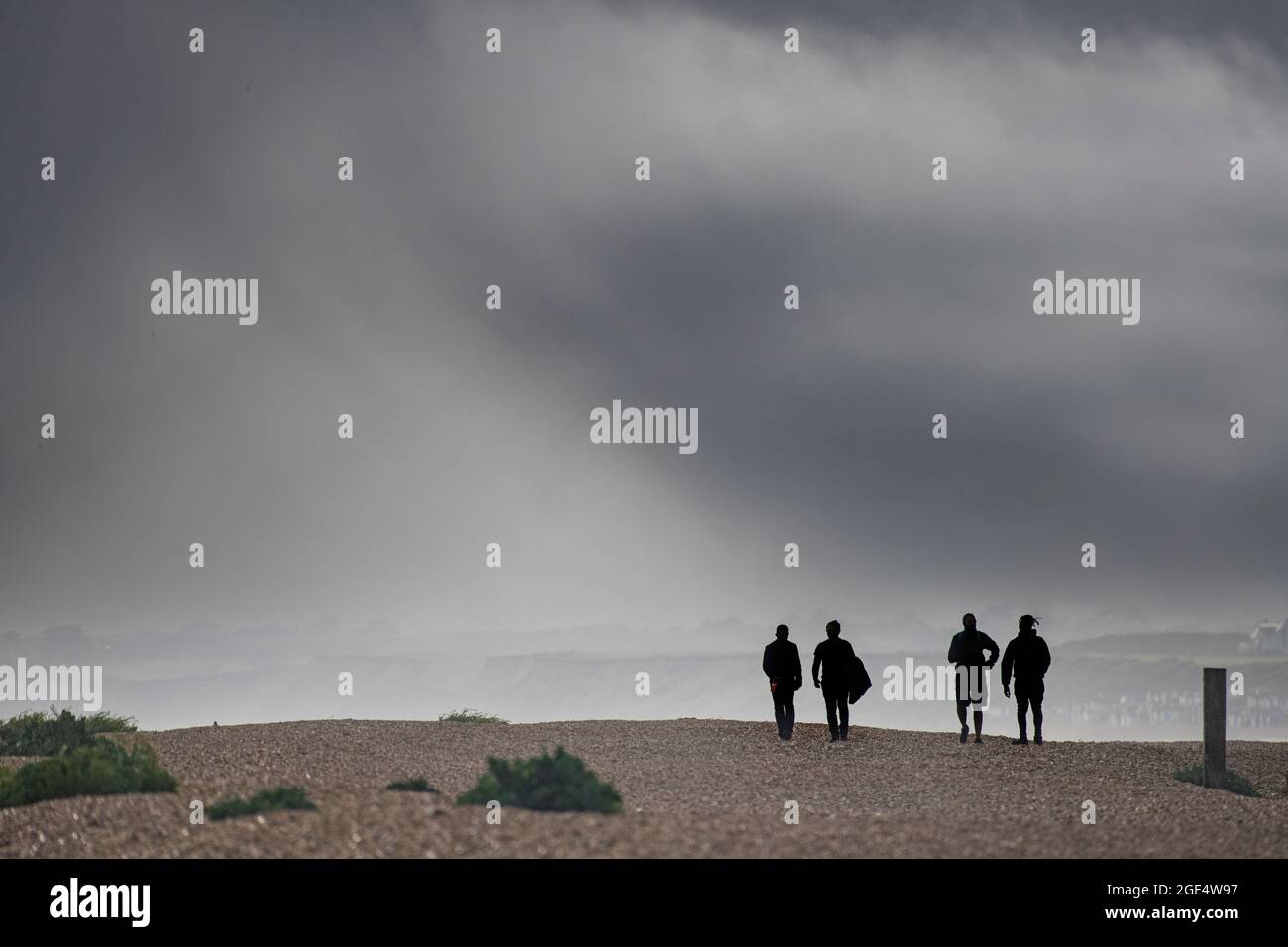 Walking along the Hurst beach spit in stormy weather, as waves crash on ...