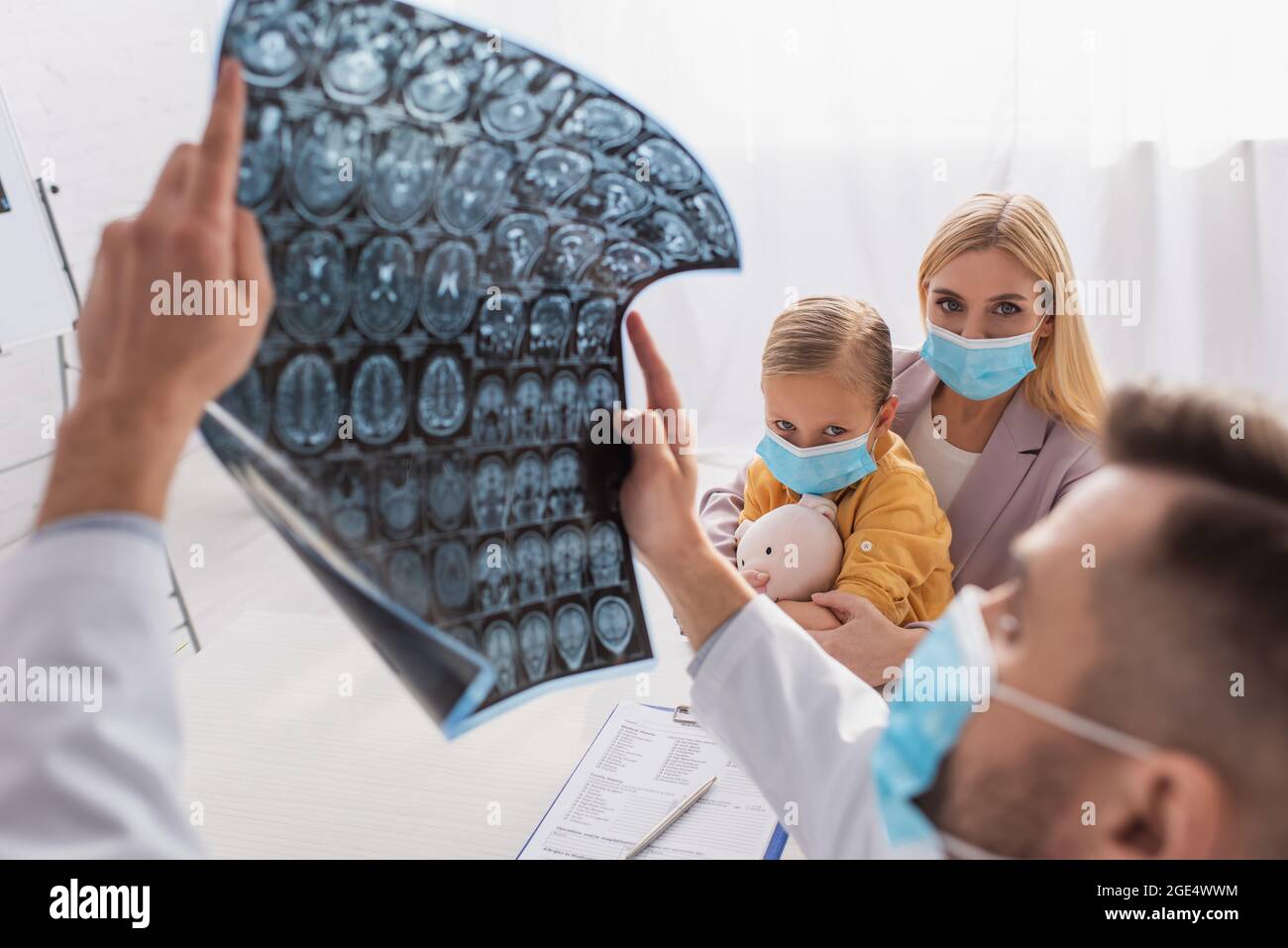 Doctor holding mri scan near mother and kid in medical masks Stock ...