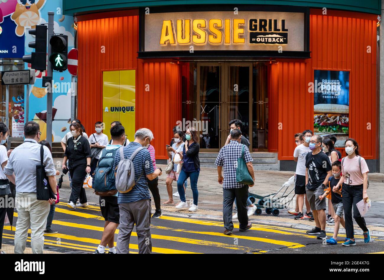 Hong Kong, China. 3rd Aug, 2021. Pedestrians cross the street in front ...