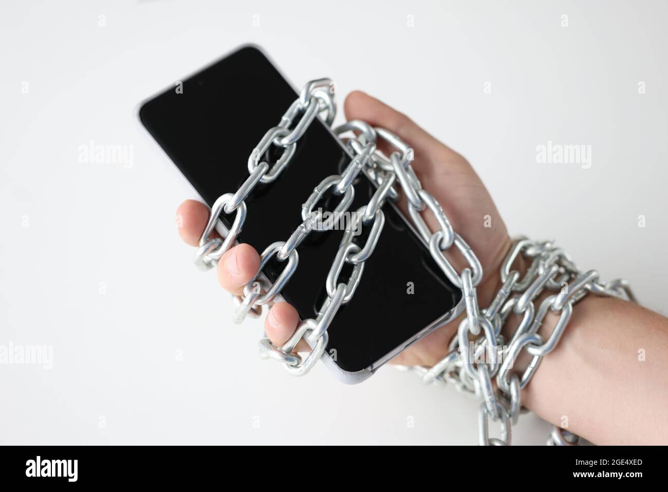 Male hands tied with chain and hold smartphone Stock Photo - Alamy