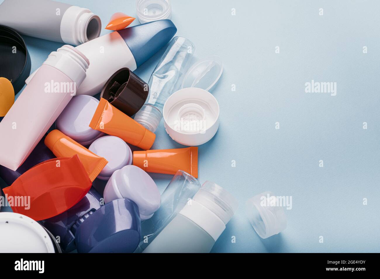 Used plastic packaging for cosmetics on a blue background. Trash with ...