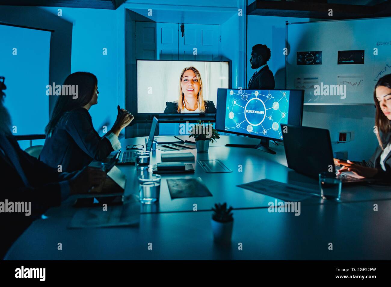 Team work watching video call from blockchain advisor inside hedge fund ...