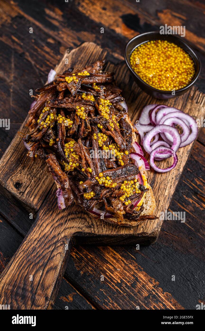 BBQ Texas Sandwich with slow roasted brisket beef meat. Dark wooden ...