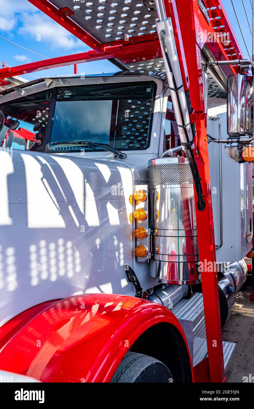Shiny red and white classic powerful industrial big rig car hauler semi ...