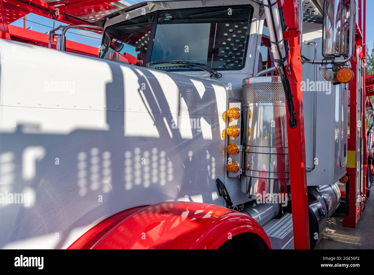 Shiny red and white classic powerful industrial big rig car hauler semi ...