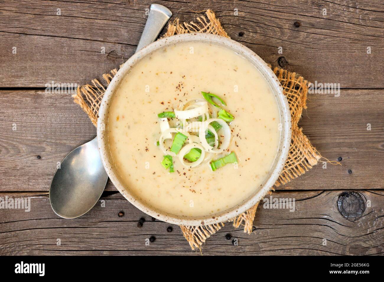 Potato and leek soup. Top view table scene on a rustic wood background ...