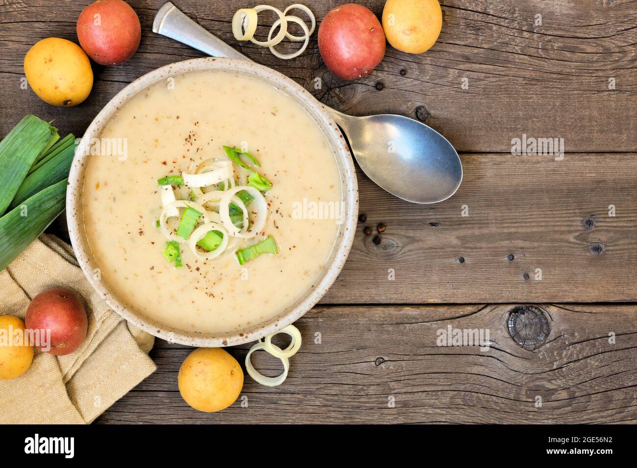 Potato and leek soup. Above view table scene on a rustic wood ...