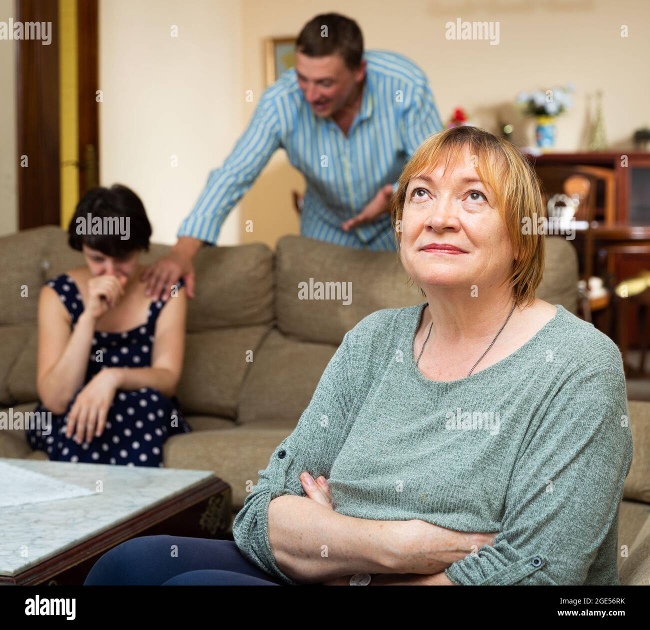 Upset elderly woman with arguing couple Stock Photo - Alamy