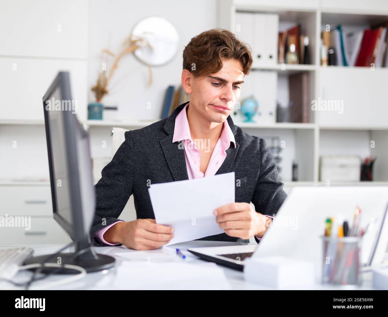 Attractive thoughtful young man working with documents Stock Photo - Alamy
