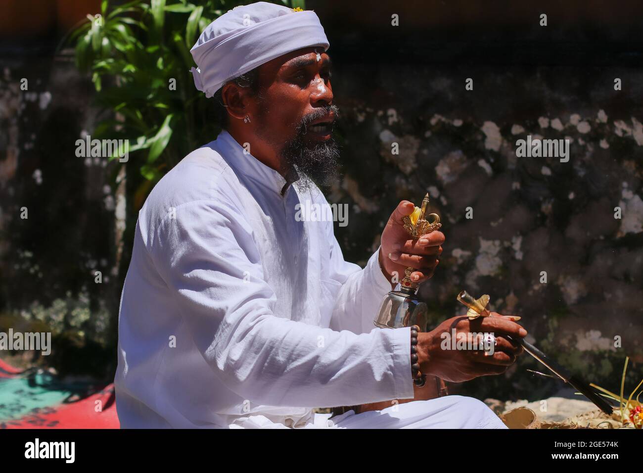 Close up of a Balinese pedanda during prayer. side view of a hindu ...